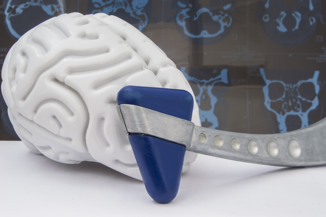 Figure of human brain with neurologic hammer on a background of spiral ...